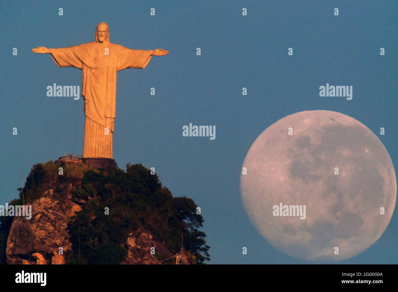 Christ the Redeemer early in the morning with the big moon in the ...