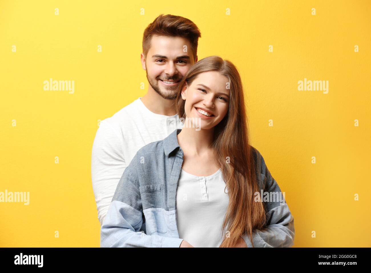 Cute young couple on color background Stock Photo - Alamy