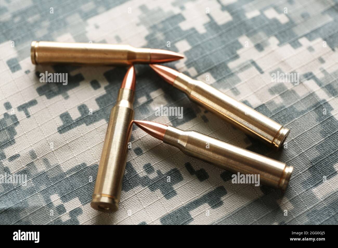 Bullets on camouflage background Stock Photo - Alamy