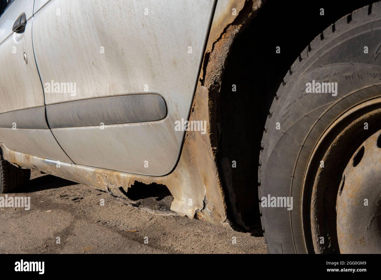 Rusty and dirty car door damaged by corrosion. Hole in the door car ...
