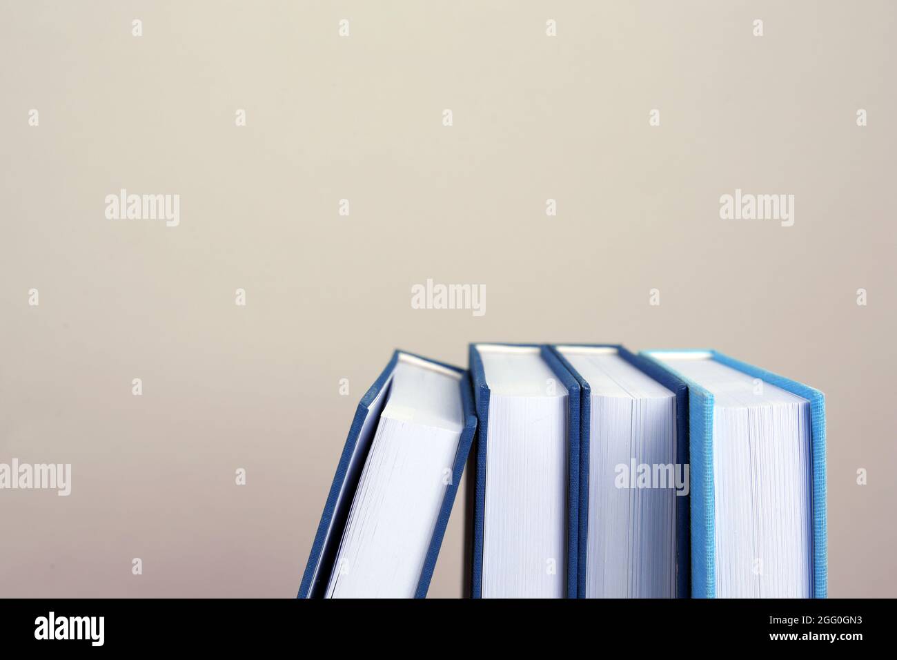 Books in a row on grey background Stock Photo - Alamy
