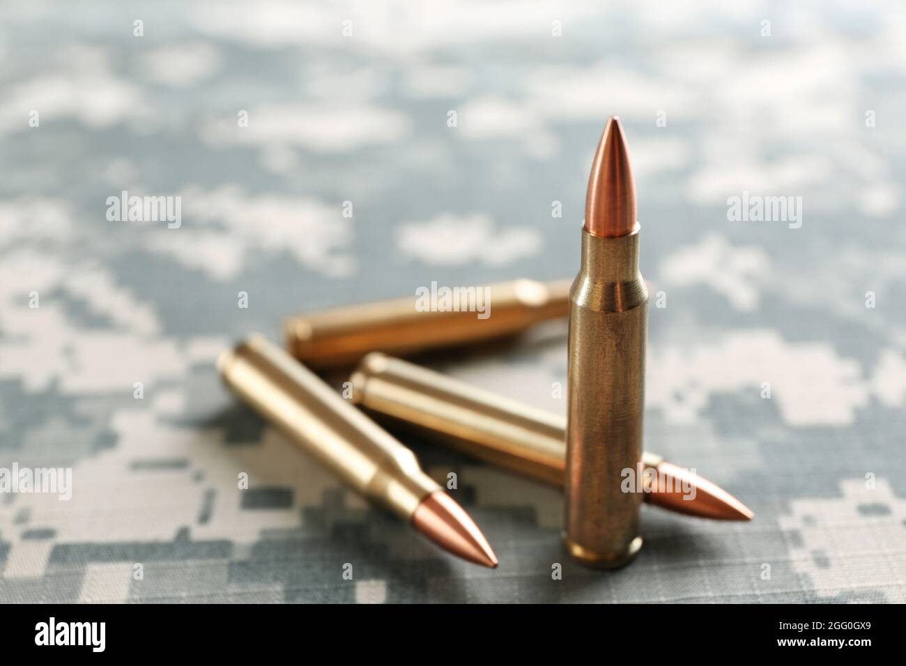 Bullets on camouflage background Stock Photo - Alamy