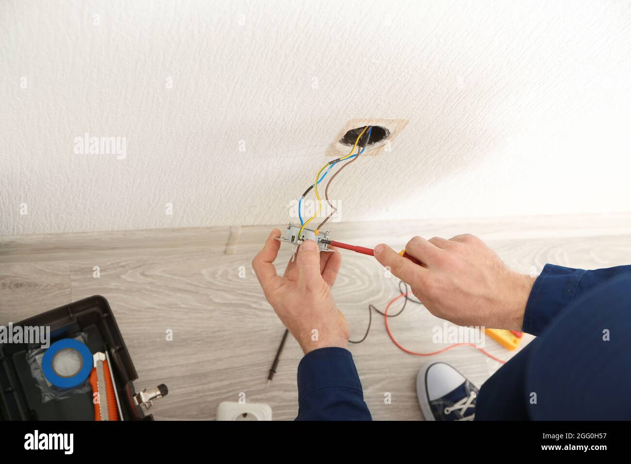 Electrician attaching wires to socket in new building Stock Photo - Alamy