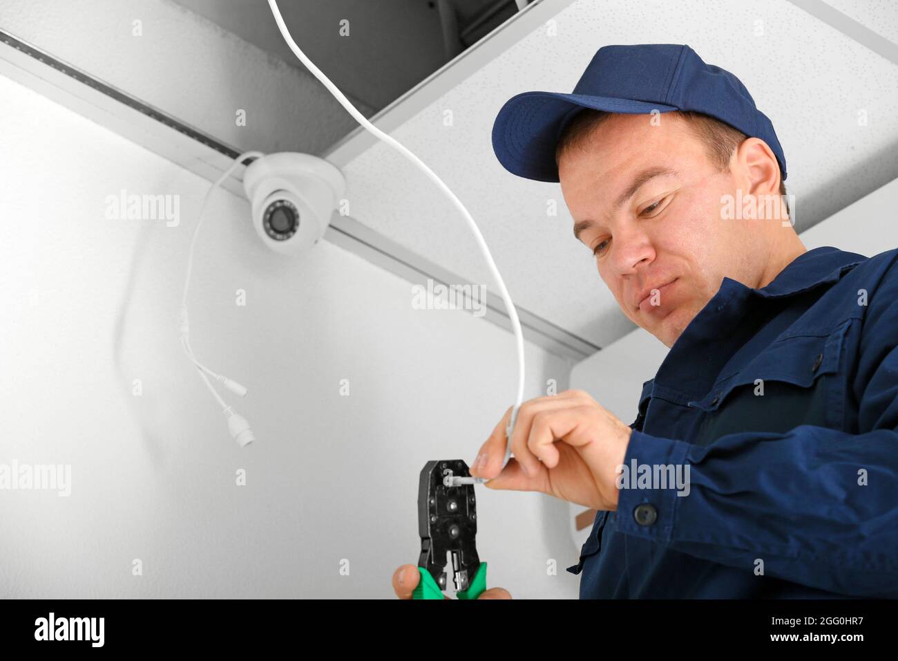 Electrician connecting CCTV camera in office Stock Photo - Alamy