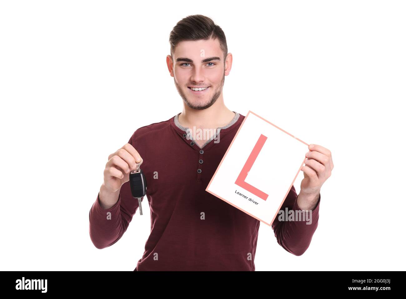 Young man with learner driver sign and car key on white background ...