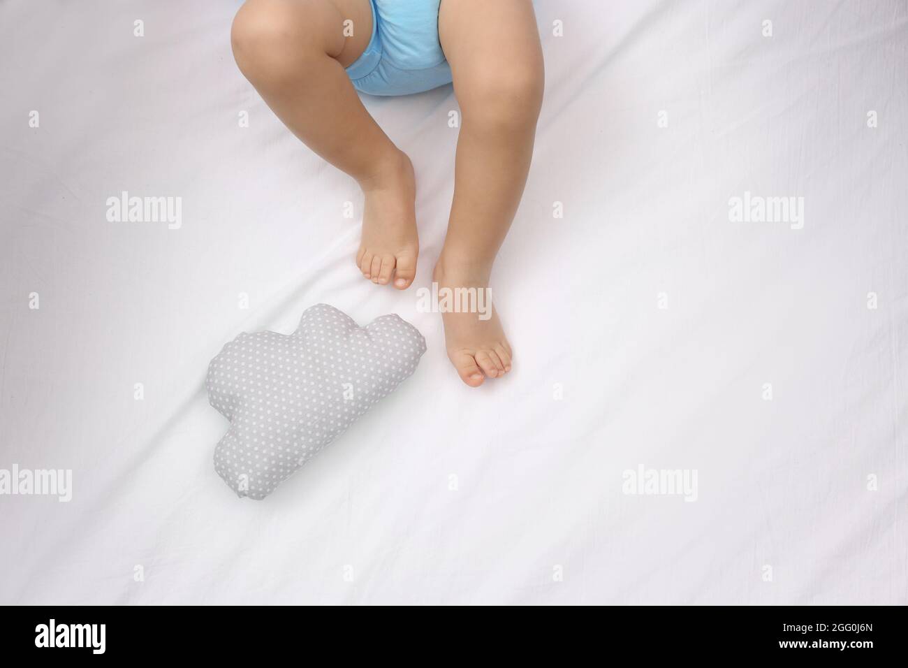 Little baby legs on bed with toy Stock Photo - Alamy