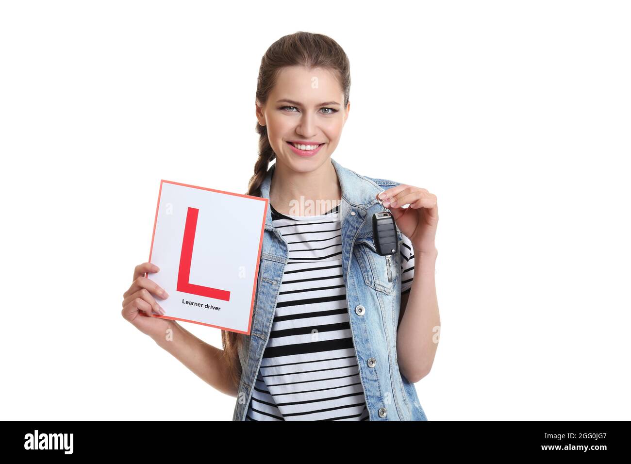 Young woman with learner driver sign and car key on white background ...