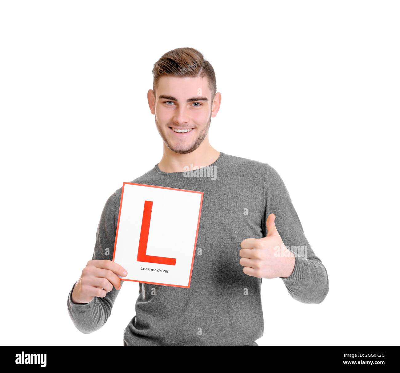 Young man with learner driver sign on white background Stock Photo - Alamy