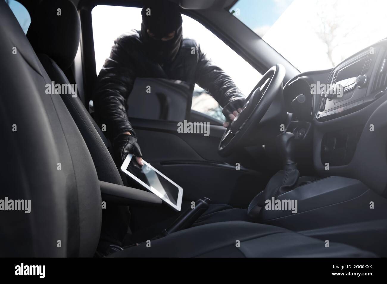 Thief stealing tablet from car Stock Photo - Alamy