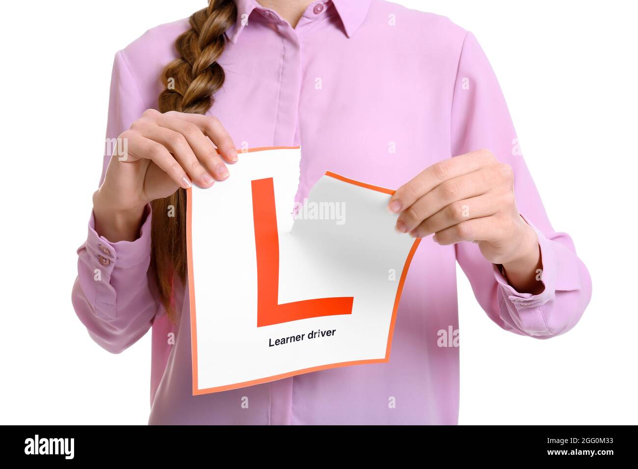 Young woman tearing learner driver sign on white background, closeup ...