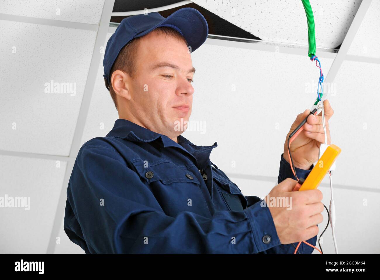 Electrician checking voltage in office Stock Photo - Alamy