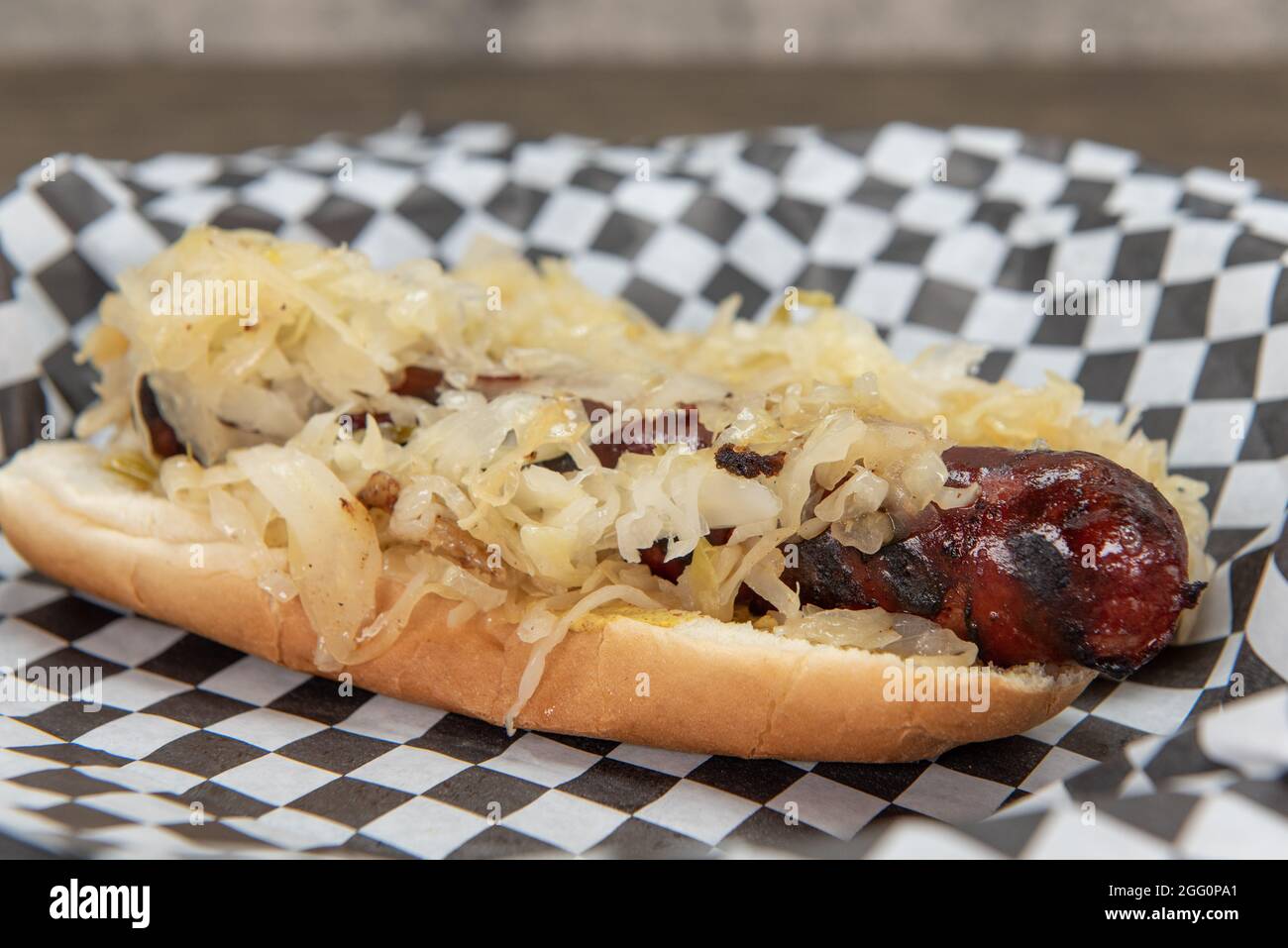 Thick hot dog in a bun loaded with sauerkraut for an appetizing meal ...