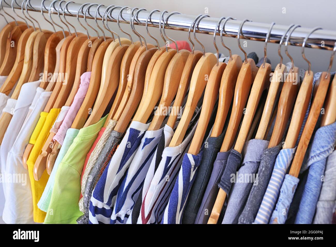 Hangers with colorful clothes on rack, closeup Stock Photo - Alamy