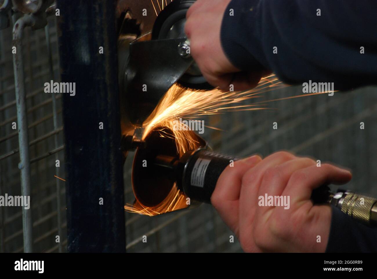 Worker grinding metal in a manufacturing plant Stock Photo - Alamy