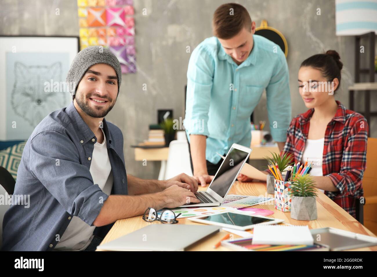 Three young designers at workplace Stock Photo - Alamy