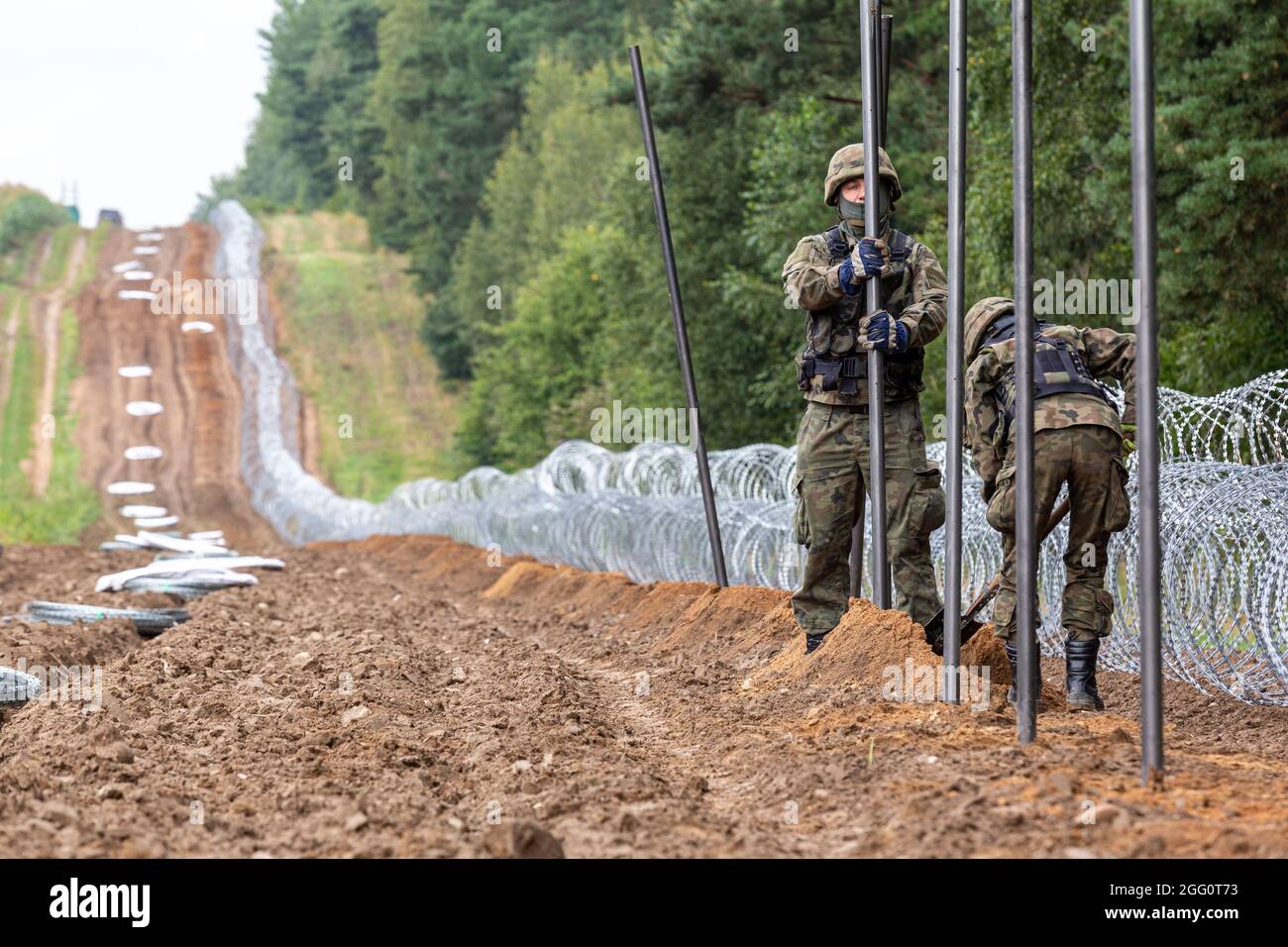 Soldiers of the Polish Army build a fence with concertina wire at the ...