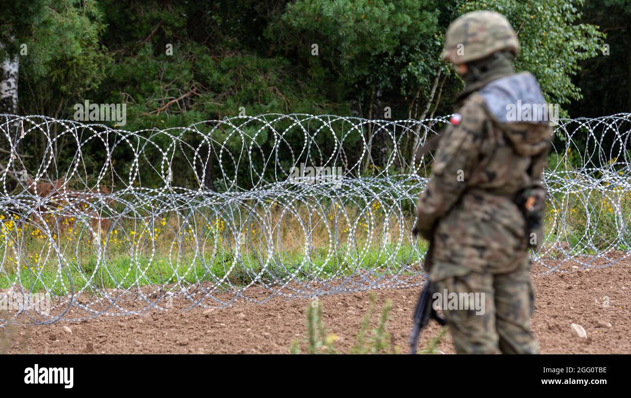 Soldiers of the Polish Army build a fence with concertina wire at the ...