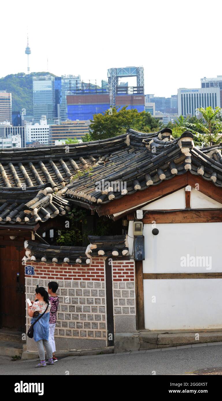 Modern Seoul as seen between the traditional rooftops of the Bukchon ...