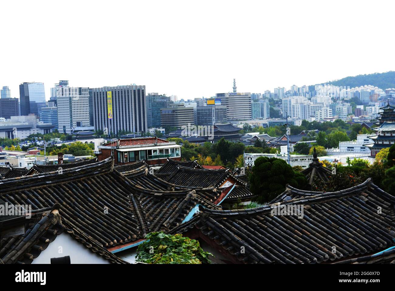Modern Seoul as seen between the traditional rooftops of the Bukchon ...