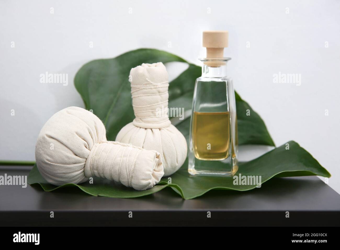 Herbal compress balls and natural oil on green leaf Stock Photo - Alamy
