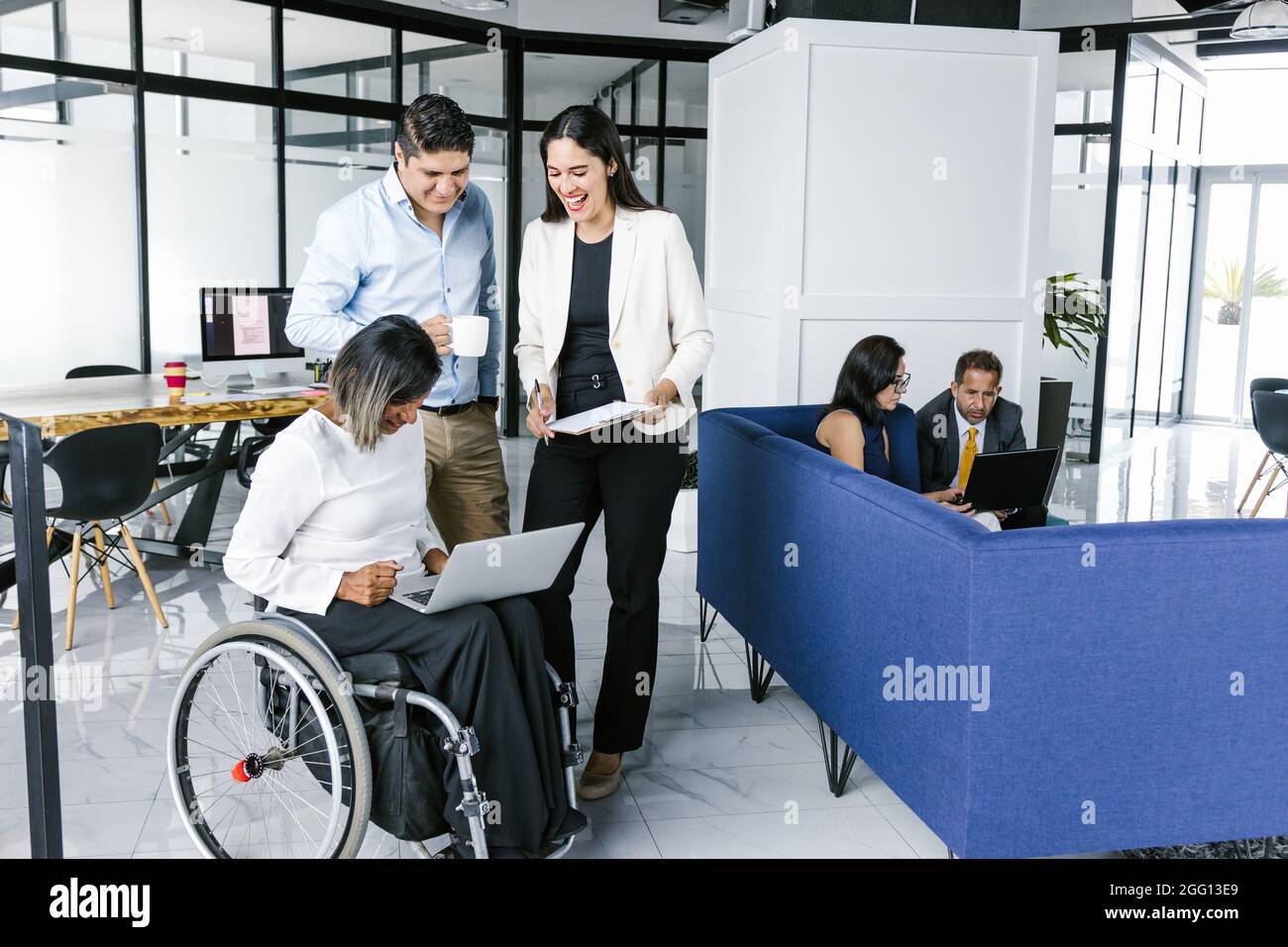 Mexican transgender woman in wheelchair working with coworkers using ...