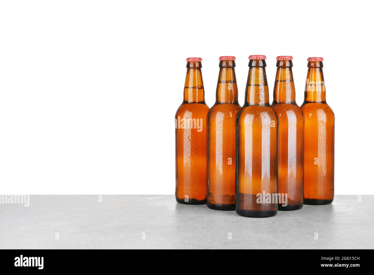 Bottles of beer on table against white background Stock Photo - Alamy