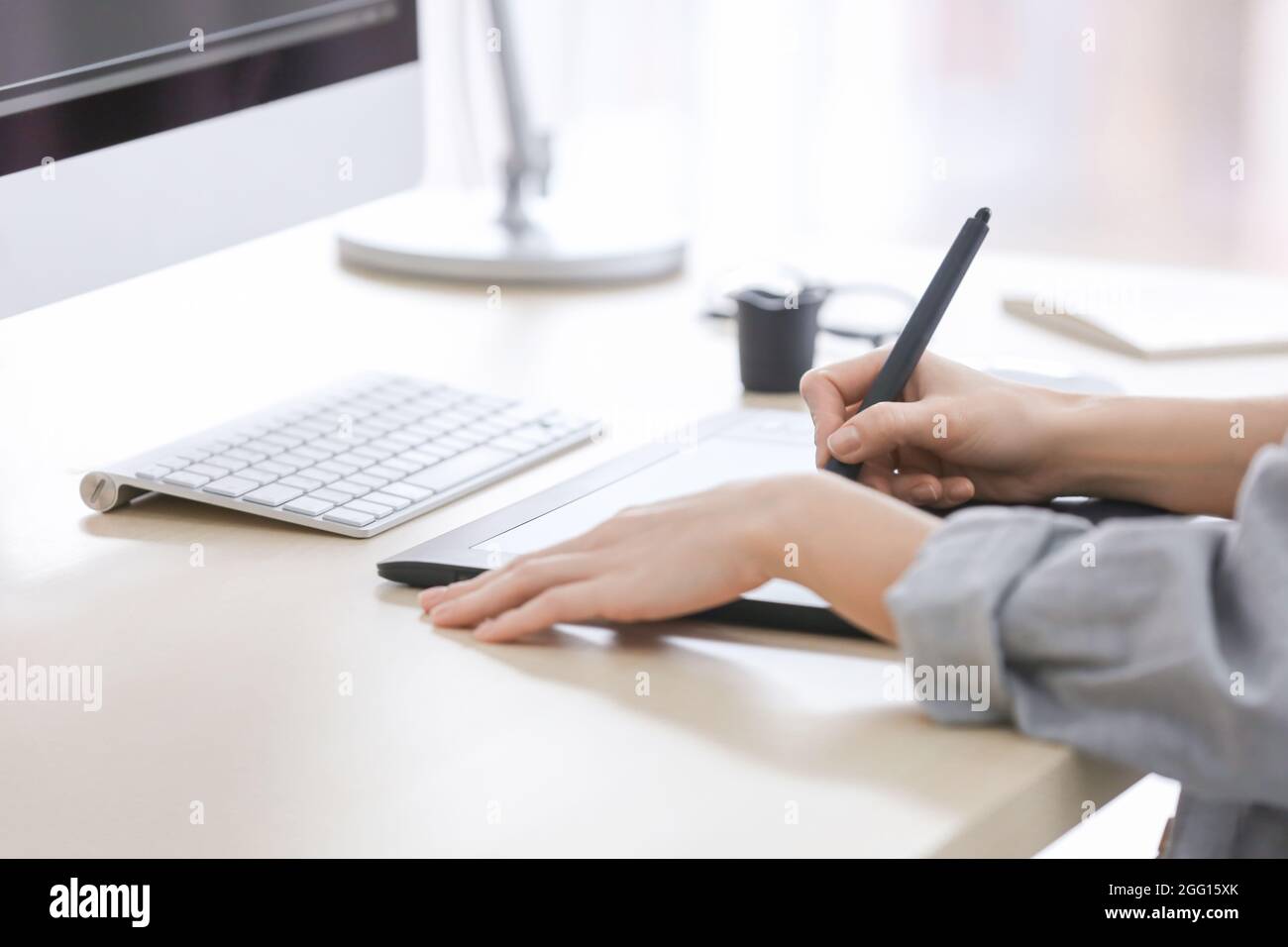 Female hands using graphic tablet in office Stock Photo - Alamy
