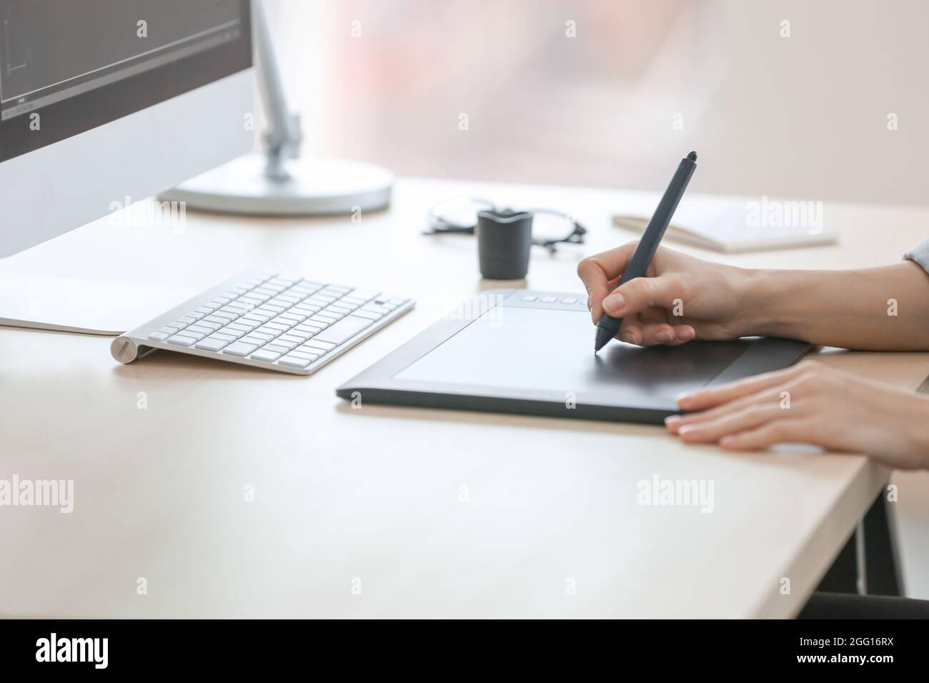 Female hands using graphic tablet in office Stock Photo - Alamy