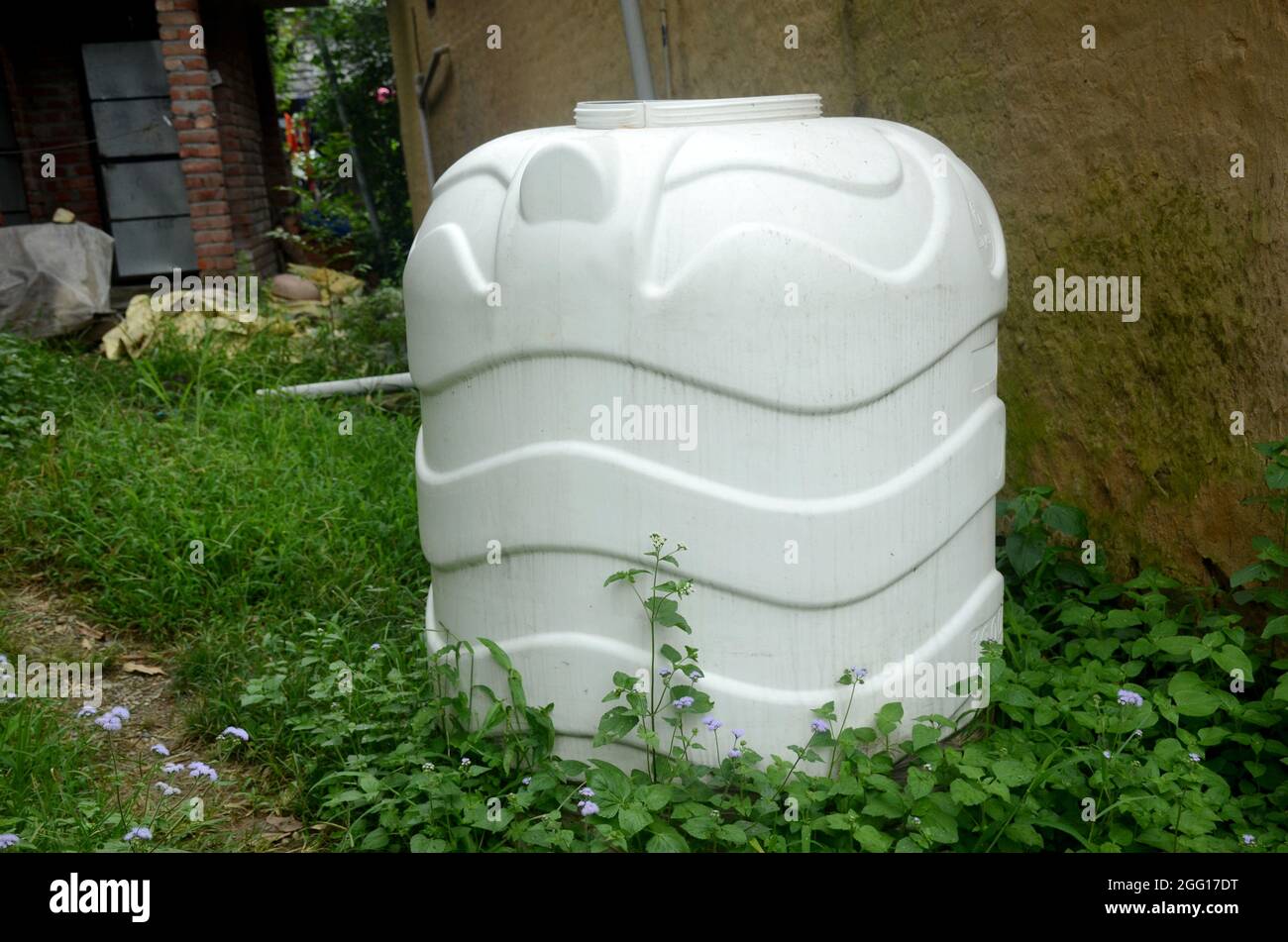 closeup the old white blank water tank keep on the green grass over out ...