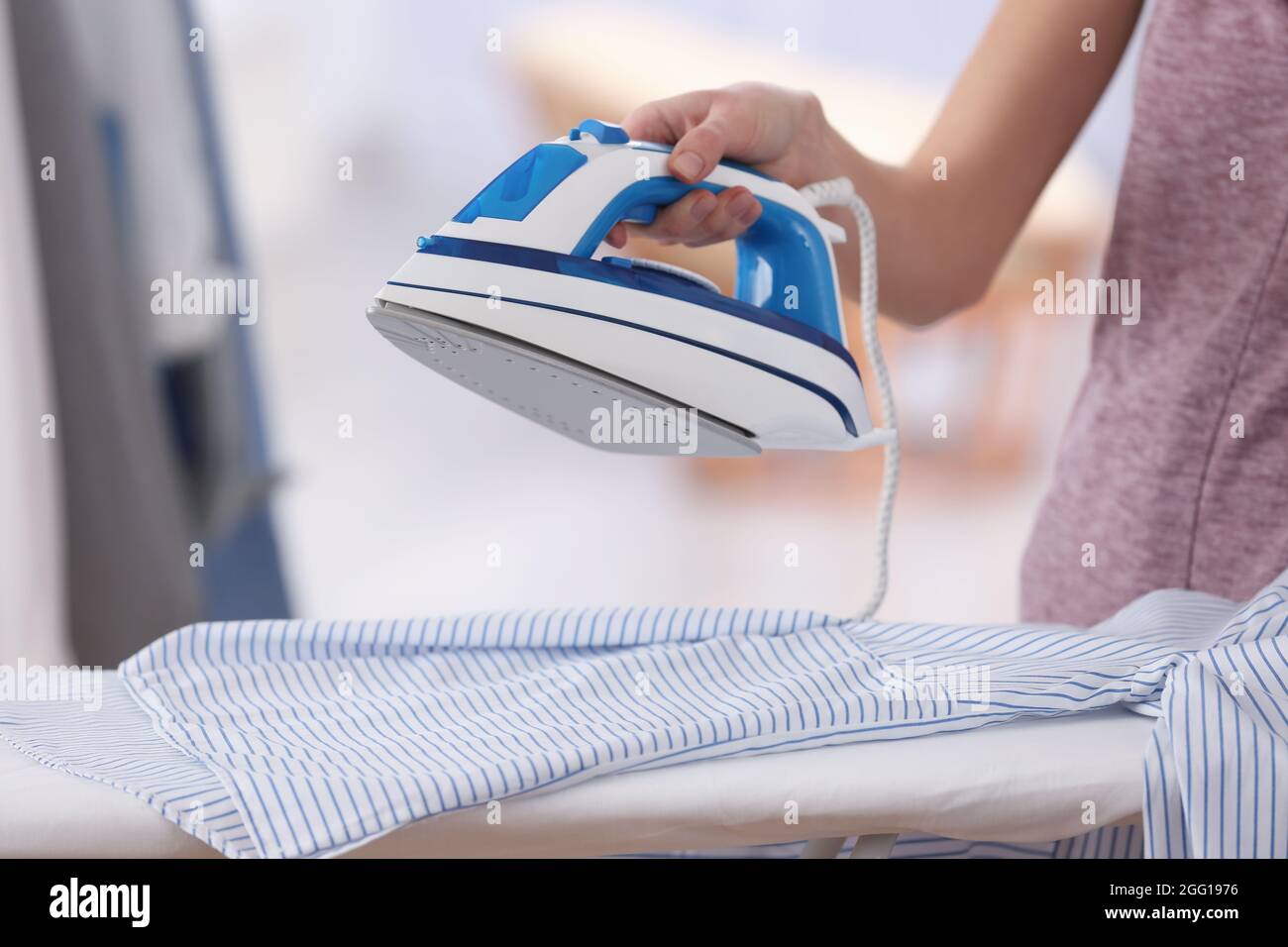 Female hand ironing clothes Stock Photo - Alamy