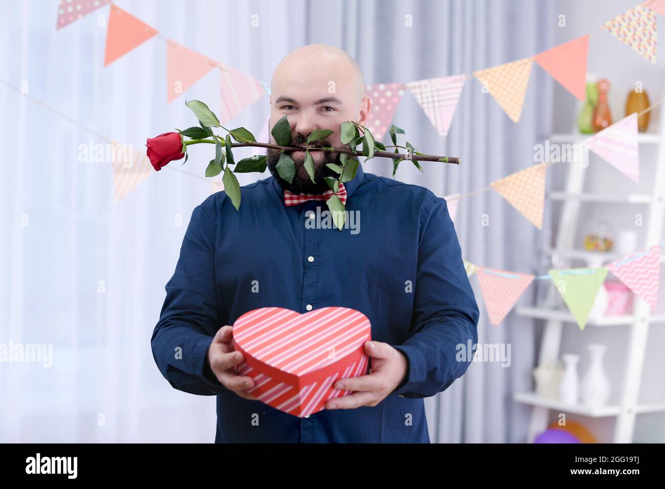 Funny fat man with giftbox and flower at birthday party Stock Photo - Alamy