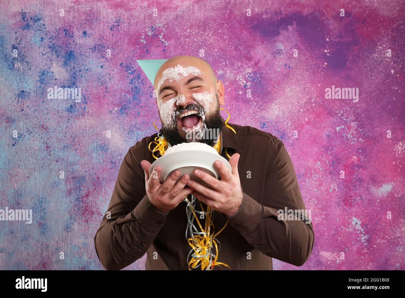 Funny fat man eating birthday cake and smearing cream on face, against ...