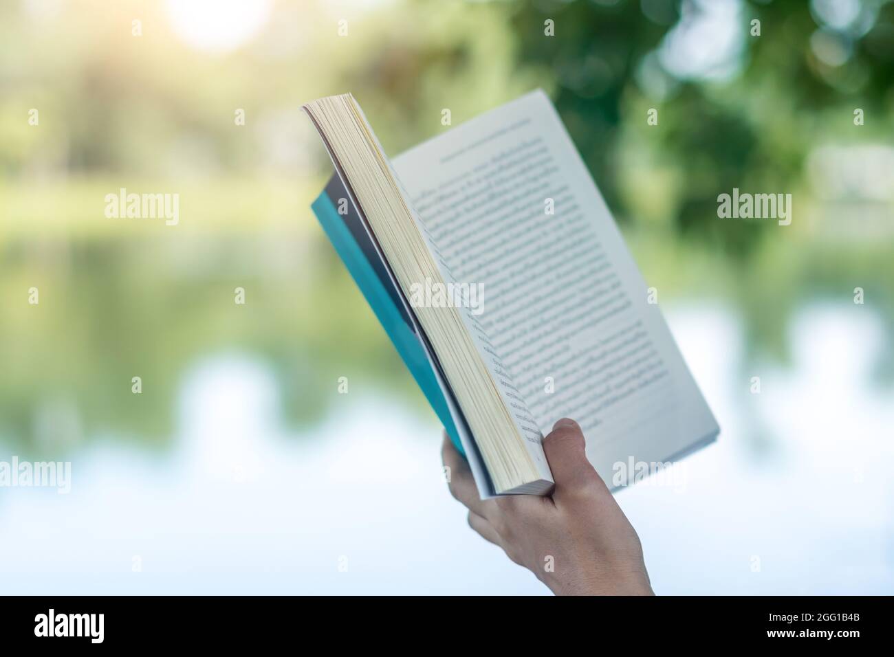 Woman is reading book in beautiful park and pond relax and peaceful ...