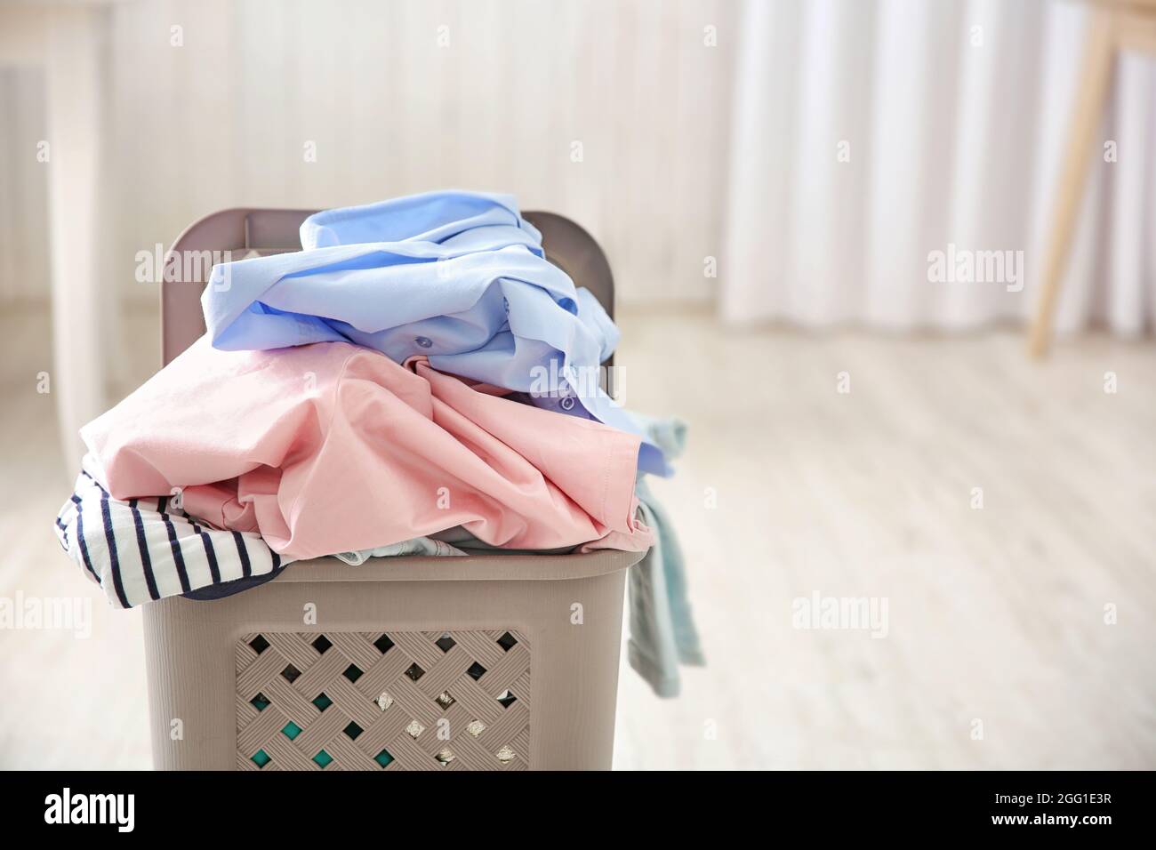 Pile of clothes in plastic laundry basket indoors Stock Photo - Alamy