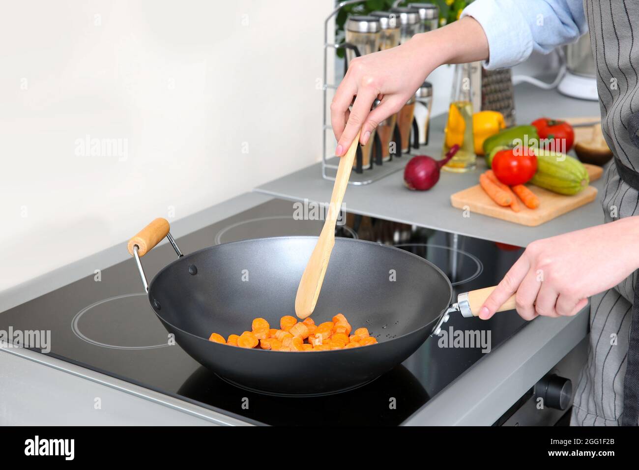 Woman mixing vegetables in pan at kitchen Stock Photo - Alamy