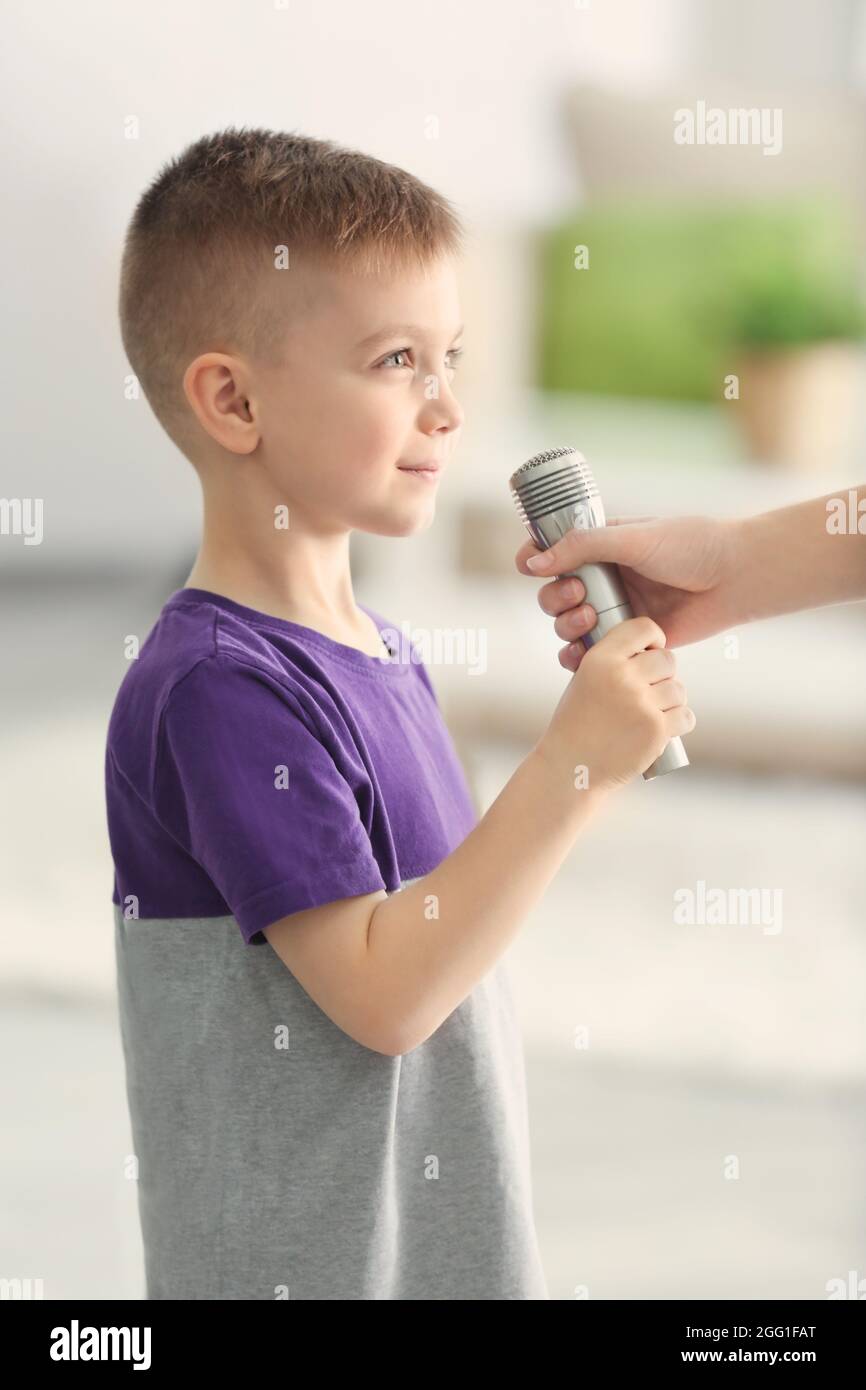 Female hand giving microphone to cute little boy at home Stock Photo ...