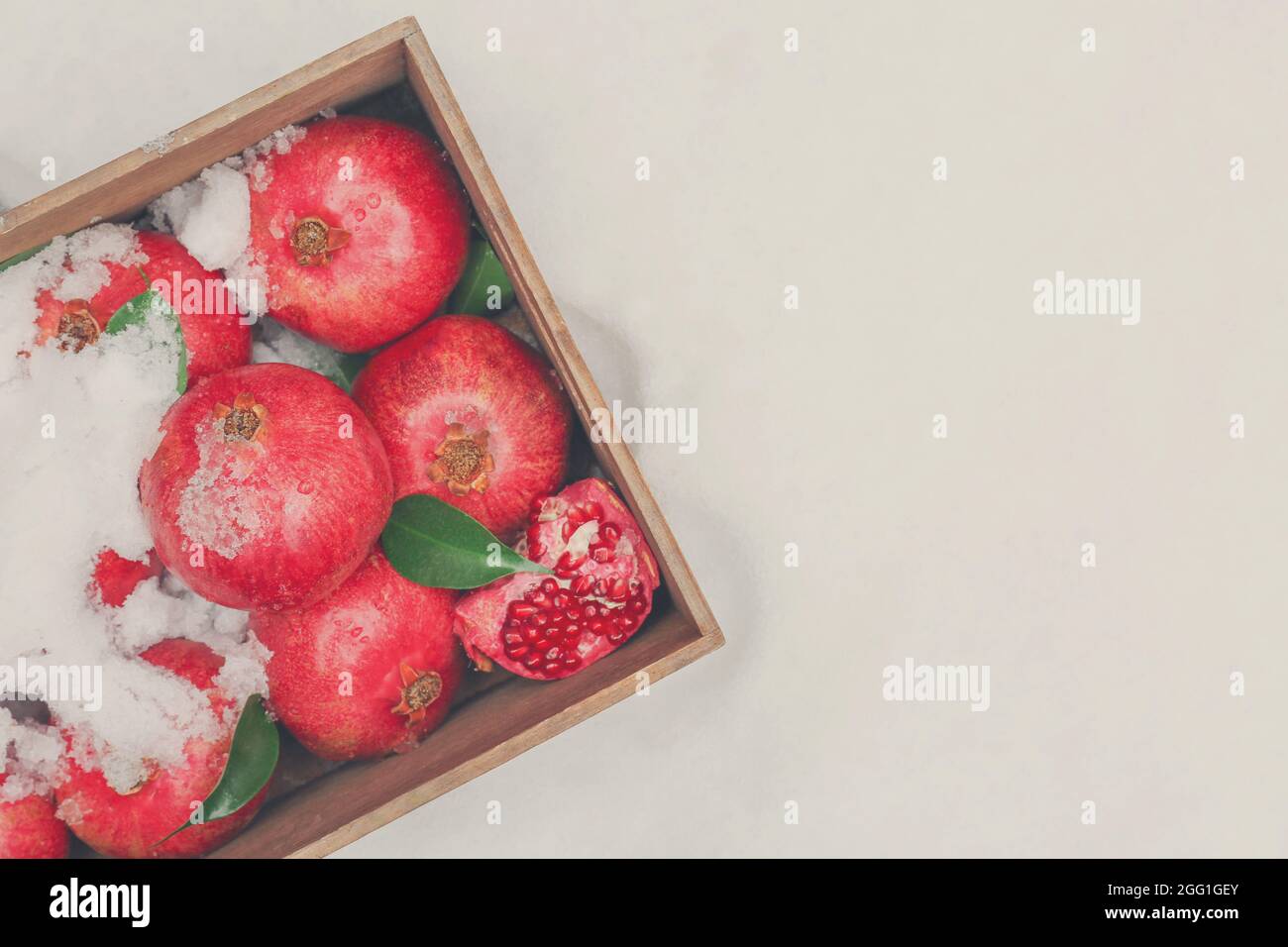 Pomegranates and snow in wooden crate Stock Photo - Alamy