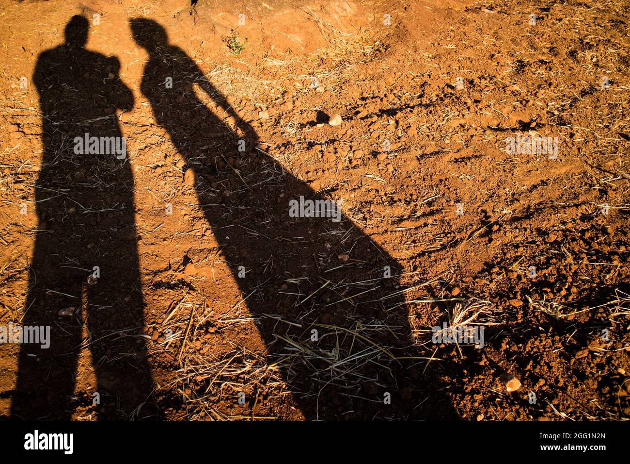 Shades produced by a photographer and a model projected on the ground ...