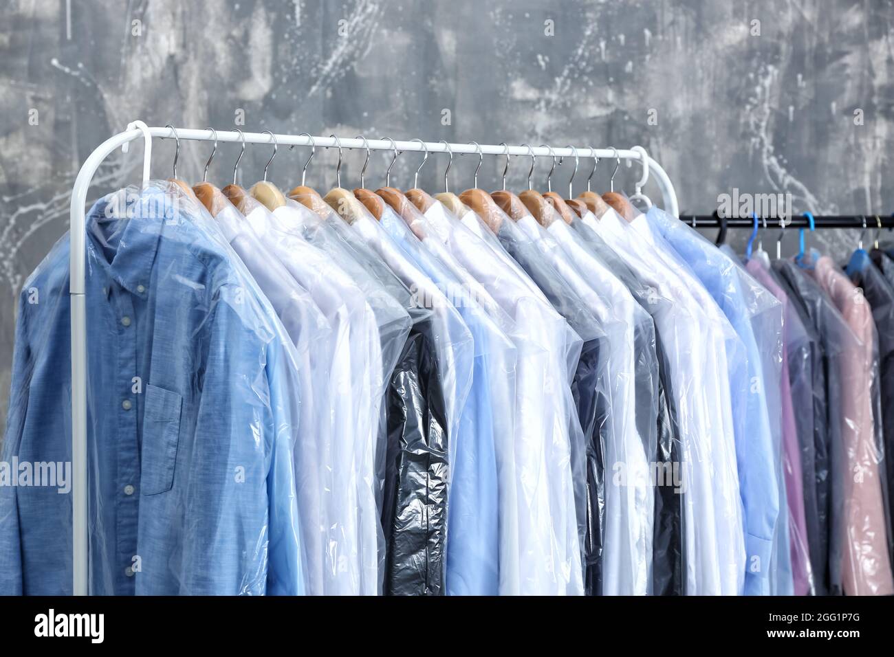 Rack of clean clothes hanging on hangers at dry-cleaning Stock Photo ...