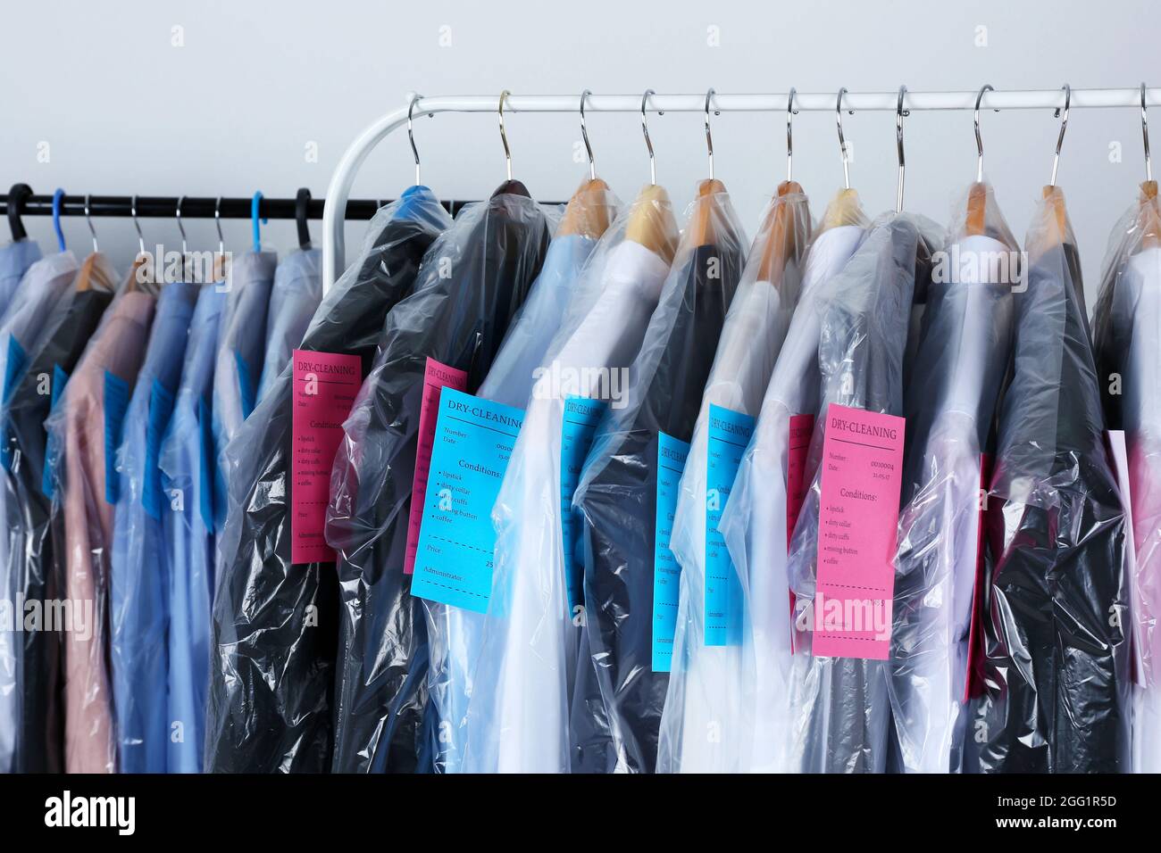 Rack of clean clothes hanging on hangers at dry-cleaning Stock Photo ...