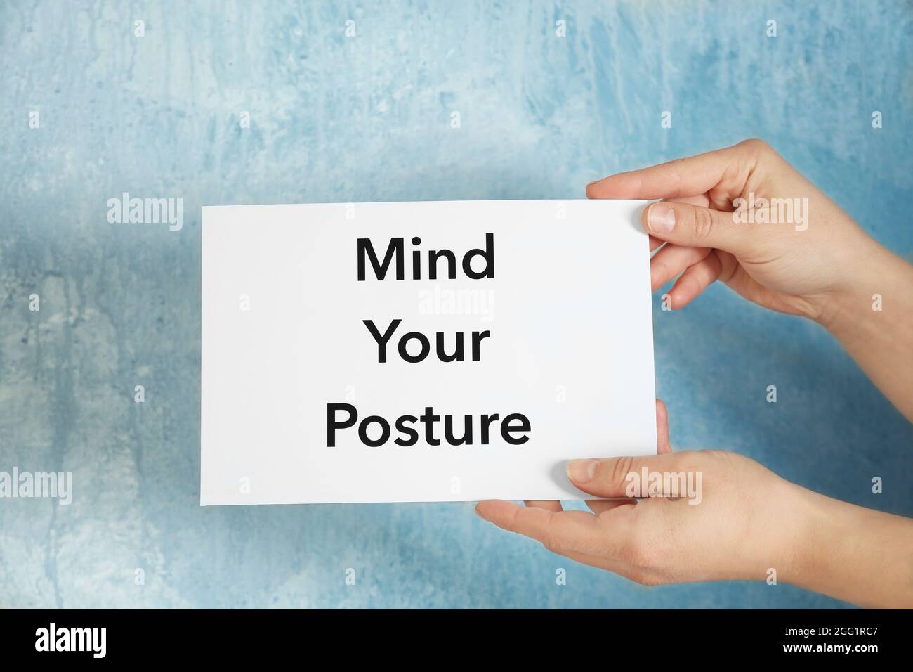 Hands holding paper with phrase MIND YOUR POSTURE on light background ...