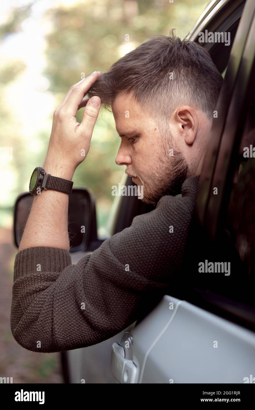 portrait of a man stick out of car window at forest trail Stock Photo ...