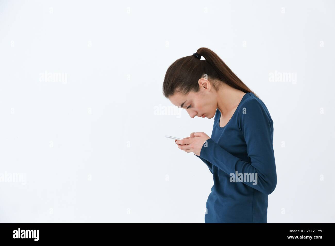 Posture concept. Young woman using smartphone against white background ...