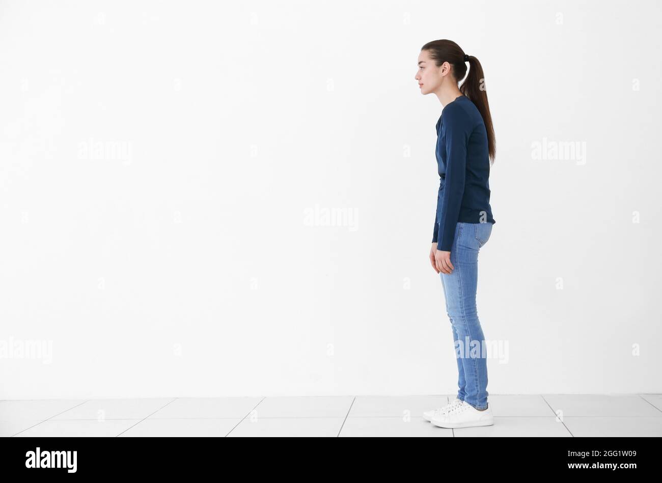 Posture concept. Young woman on white wall background Stock Photo - Alamy