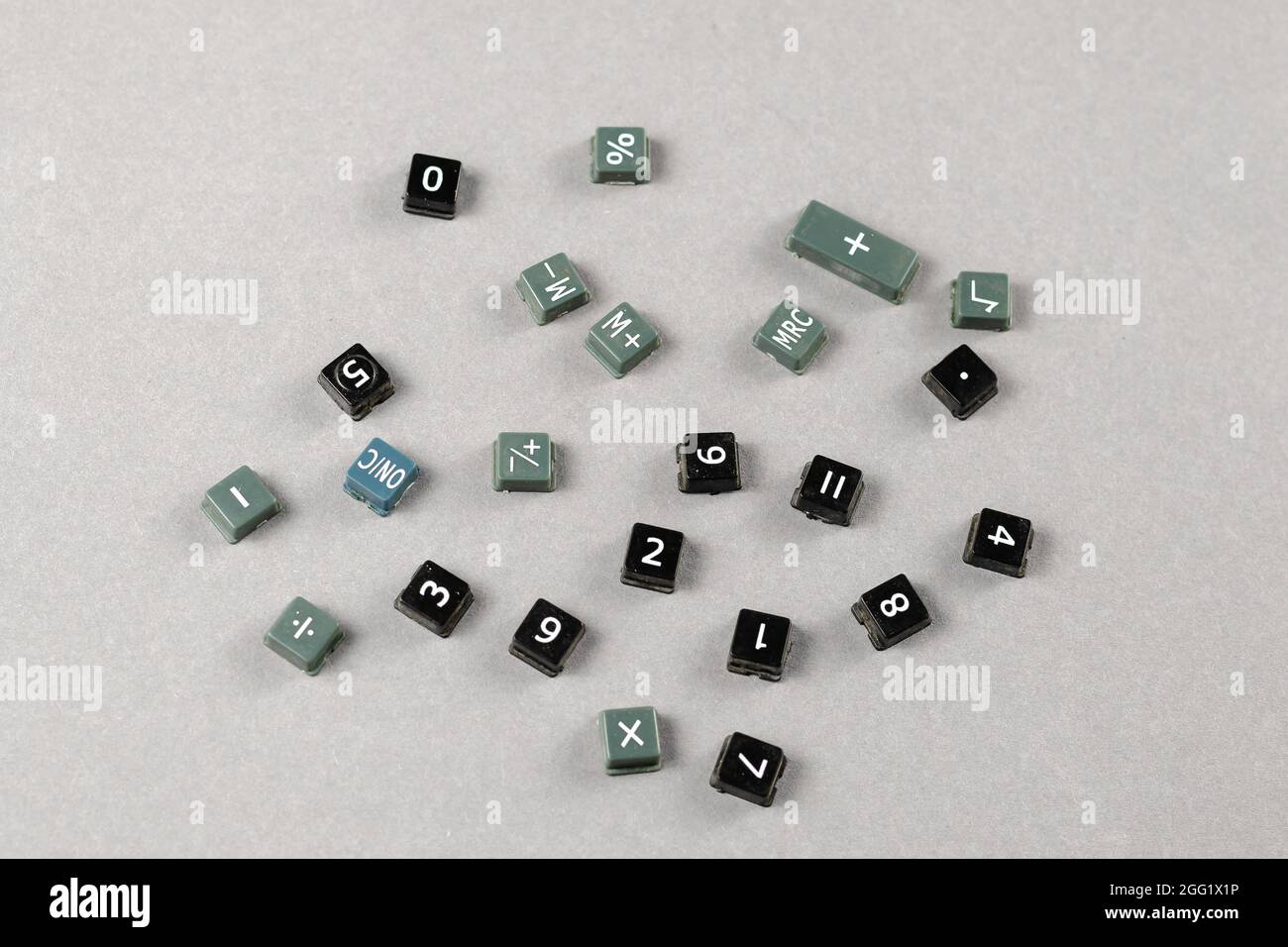 Broken and disassembled calculator buttons on gray background. Small ...