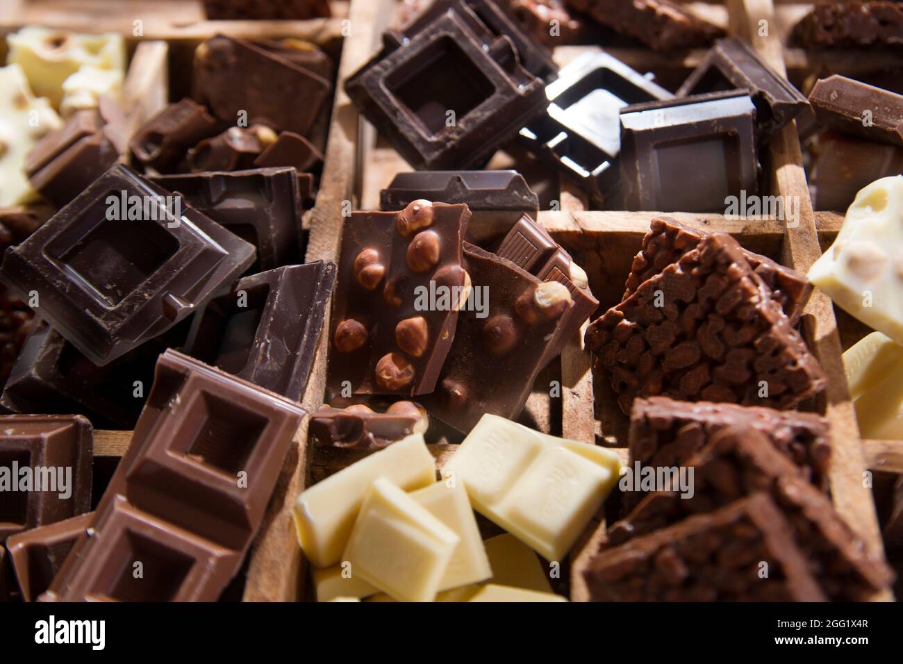 Little cubes of chocolate in various colors in wooden box Stock Photo ...