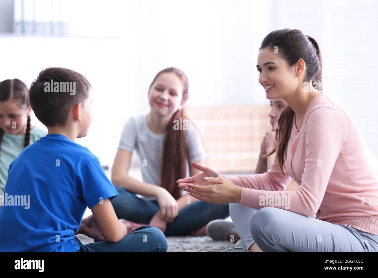 Female teacher conducting lesson at school Stock Photo - Alamy