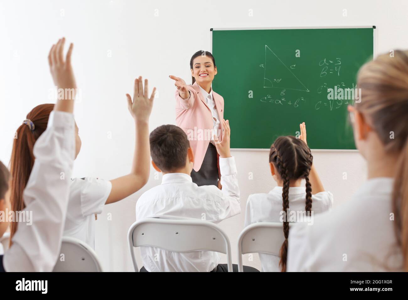 Female teacher conducting lesson in classroom Stock Photo - Alamy