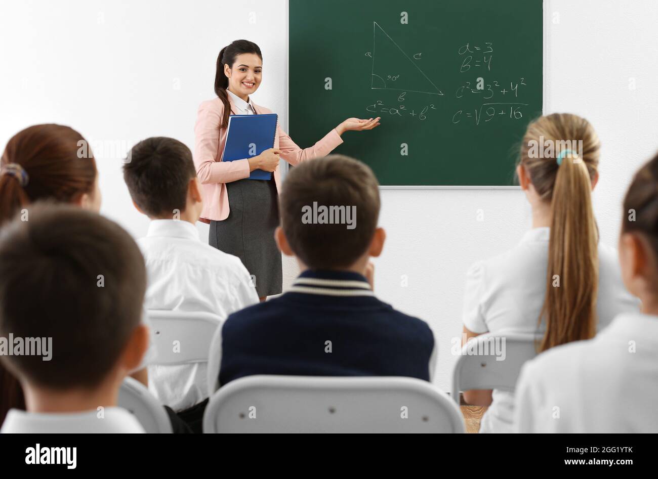 Female teacher conducting lesson in classroom Stock Photo - Alamy