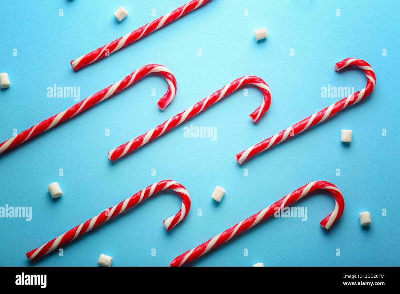 Sweet candy canes on light blue background Stock Photo - Alamy